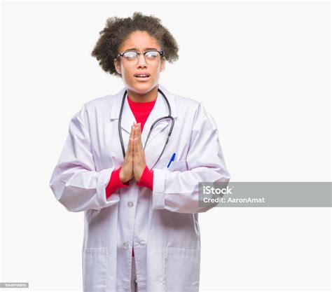 구걸 하 고 손으로 얼굴 매우 감정적이 고 걱정에 희망 식 함께 기도 격리 된 배경 위에 젊은 아프리카 미국 의사 여자 용 서에 대 한 요구 종교 개념입니다 감정에 대한