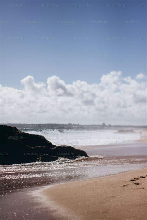 서핑보드를 들고 해변을 걷는 사람 사진 Unsplash의 월페이퍼 이미지