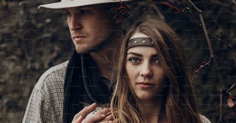 아름 다운 갈색 머리 집시 소녀 보헤미안 화이트 스웨터를 입은 힙 스터 여자는 카우보이 모자에 잘 생긴 남자와 손을 잡고 무료 커플 야외 사진 Unsplash의