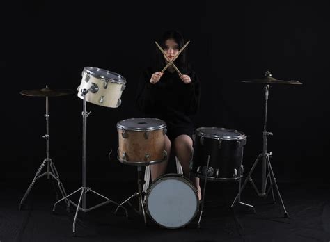 Premium Photo Girl Plays Drums On A Black Background