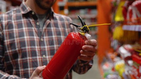 A Man In Auto Shop Chooses A New Car Fire Extinguisher Small Fire