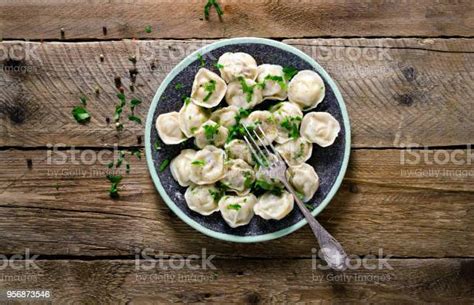 전통적인 러시아어 Pelmeni 라비 올 리 밀가루 파 슬 리 메 추 라 기 계란 후추 로즈마리 베이 리프와 향신료와 함께 나무 테이블에 고기만 두 최고의 볼 수 있습니다