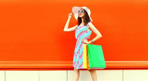 도시에서 드레스와 여름 밀짚 모자를 착용 화려한 쇼핑백을 가진 아름다운 행복한 젊은 여성 20 29세에 대한 스톡 사진 및 기타 이미지 20 29세 25 29세 가방