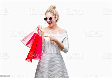 젊은 아름 다운 금발 여자를 들고 쇼핑 가방 격리 된 배경 매우 행복 손과 손가락을 가리키는 가리키기에 대한 스톡 사진 및 기타 이미지 Istock