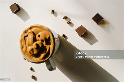 신선한 달고나 커피의 세라믹 화이트 컵 푹신한 크림 휘핑 커피 자연 광 초콜릿 큐브와 커피 콩 흰색 테이블 상단보기 커피 거품에 선택적 초점 0명에 대한 스톡 사진 및 기타