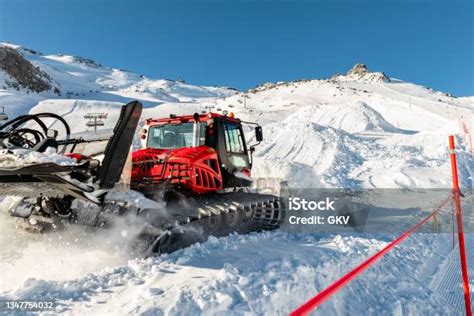 오스트리아의 알파인 스키 윈터 리조트 이쉬글에서 스키 슬로프 피스트 힐을 준비하는 스노우플러 스노우 그루밍 머신이 있는 레드 모던 스노우캣 트랙 중장비 산악 장비 트랙 차량