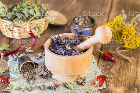 치료와 매운 향신료를 위한 향기로운 말린 치유 허브 모 르 타르의 식탁에는 소박한 스타일의 바 질 Tansy 후추 칠리와 카 다 멈이 있습니다 한방약에 대한 스톡 사진 및