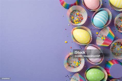 부활절 장식 밝은 다채로운 작은 뿌리의 최고 보기 는 고립 된 파스텔 보라색 배경 카피 스페이스에 컵 케이크 케이스에 많은 무지개 계란 다른 크기와 별을 뿌려 부활절