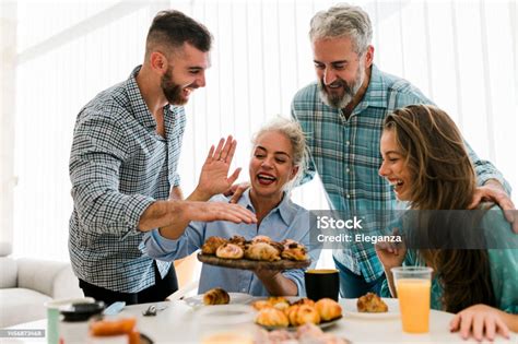 실내에서 함께 식사하는 행복한 가족 아침 식사 중에 식탁에 앉아 웃는 세대 가족 거실에서 함께 식사를 즐기는 행복한 쾌활한 가족 4 명에 대한 스톡 사진 및 기타 이미지