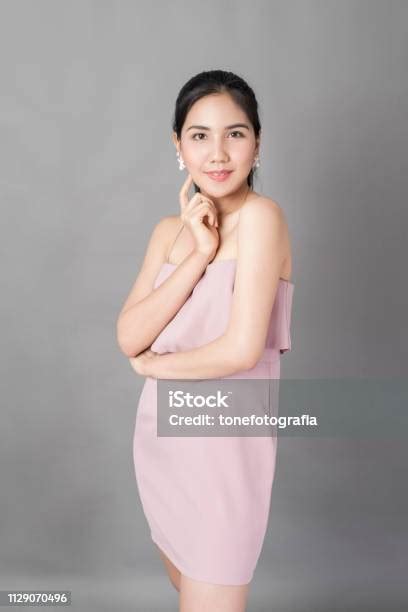 회색 배경 스튜디오 촬영에서 분홍색 드레스에 건강 한 아름 다운 여자의 초상화 가리키기에 대한 스톡 사진 및 기타 이미지 가리키기 갈색 머리 건강한 생활방식 Istock