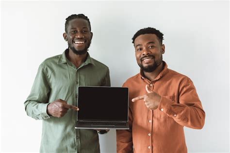 Dois Caras Negros Felizes Mostrando A Tela Do Laptop Sobre Fundo Branco