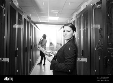 Female IT Engineer Working On A Tablet Computer In Server Room At Modern Data Center Stock Photo