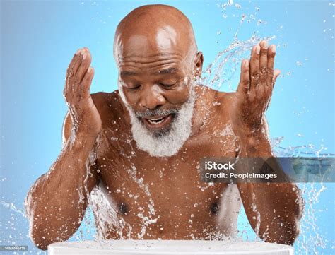 남성 성숙한 또는 물 튀김 얼굴 스킨 케어 아침 그루밍 루틴 또는 얼굴 청소 피부과 및 건강 관리 웰빙 파란색 배경에 검은색 모델에 대한 사람 세탁 위생 또는 자기 관리