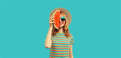 파란색 배경에 밀짚모자를 쓰고 신선한 육즙이 많은 수박 조각을 가진 행복한 미소 짓는 젊은 여성의 여름 초상화 성인에 대한 스톡 사진 및 기타 이미지 Istock