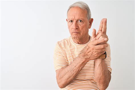 고립 된 흰색 배경 위에 서있는 줄무늬 티셔츠를 입은 선임 회색 머리 남자손 제스처로 상징적 인 총을 들고 살인 사격 무기 화가 난 얼굴 T 셔츠에 대한 스톡 사진 및 기타