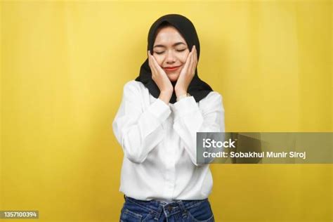 아름다운 젊은 아시아 무슬림 여자 행복 미소 귀여운 편안한 느낌 걱정 좋은 느낌 노란색 배경에 고립 된 뺨을 들고 손으로 20