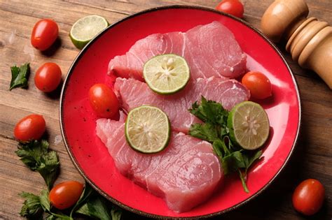 빨간 세라믹 접시에 생선 필레 필레는 생선의 한쪽 면을 척추와 평행하게 세로로 잘라 뼈에서 잘라내거나 얇게 썬 생선입니다 말린 Istiompax Indica 0명에 대한