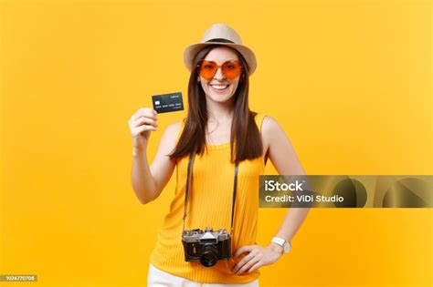 재미 있는 여름 캐주얼 옷에 관광 여자 모자 신용 카드와 고글 노란색 오렌지 배경에 고립 된 제스처를 엄지손가락 주말도 주에 해외 여행 여행 소녀입니다 공기 비행 개념입니다