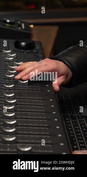 Close Up Of Hands Adjusting Knobs And Faders On A Digital Audio Mixing