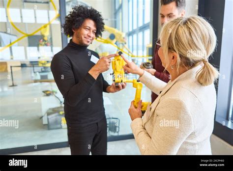 Group Of Engineers Engaging In A Discussion About Robotics Design And Programming In A Modern