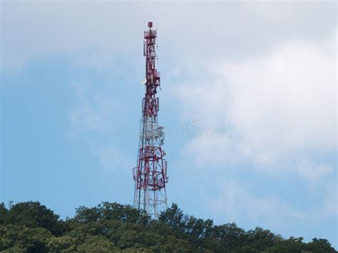 Directional Antenna Array On A Red And White Communication Tower