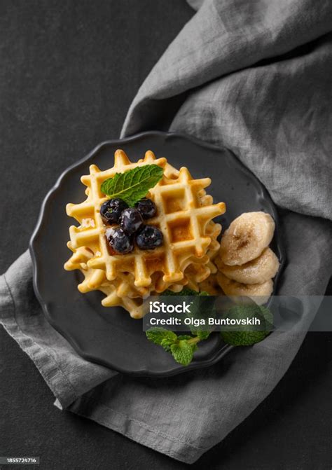 키위 바나나 슬라이스 민트를 곁들인 벨기에 와플이 쌓여 있고 어두운 배경의 회색 접시에 꿀 시럽이 뿌려져 있습니다 카페에 대한 스톡 사진 및 기타 이미지 Istock