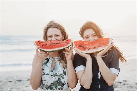 Premium Photo Portrait Of Lesbians Eating Watermelon At Beach