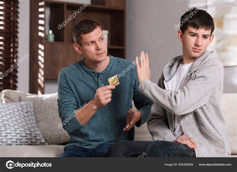 Father Talking His Teenage Son Contraception Home Sex Education Concept