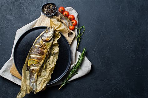 검은 접시에 크 래 프 트 종이에 구운 된 농 어 검정색 배경 평면도 텍스트 공간 검은색에 대한 스톡 사진 및 기타 이미지 검은색 고추류 굽기 Istock