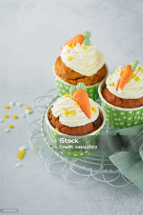 부활절을위한 당근 케이크 컵 케이크 흰색 바탕에 작은 마지팬 당근으로 장식된 크림 치즈 프로스팅을 곁들인 당근 컵케이크 행복한 부활절과 봄 휴가 개념 홀리데이 홈메이드