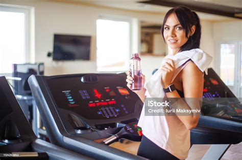 스포츠와 건강 한 라이프 스타일의 개념입니다 젊은 매력적인 피트 니스 여자 디딜 방 아에서 실행에서 흰 운동복 입고 디딜 방 아에 심장 운동을 하 고 건강 한 스포티 한