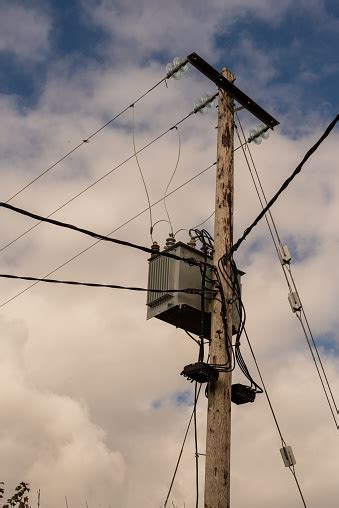Ac 고전압 전원 변압기 푸른 하늘을 배경으로 고전압을 저전압으로 전환하는 나무 기둥 분배 변압기를 통해 최종 사용자에게 전력을