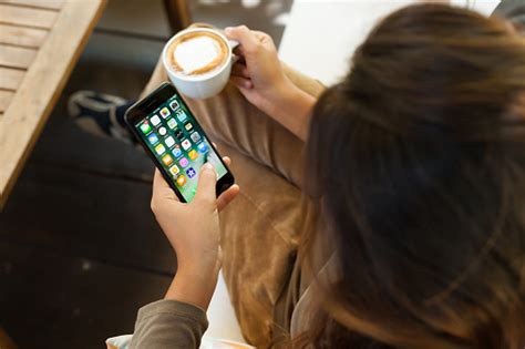 클로즈업 여자 들고 새로운 아이폰 7 보여주는 애플 리 케이 션 스크린 커피숍에서 아이폰 7은 애플 I N C에 의해 제조 하는 새로운 스마트폰 각도에 대한 스톡 사진 및