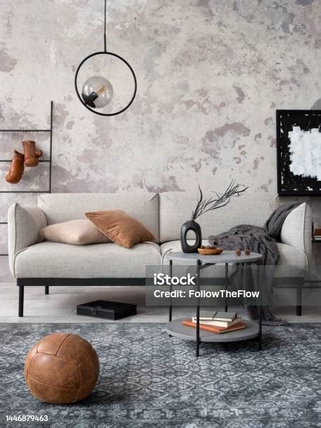 회색 디자인 소파 검은색 커피 테이블 검은색 사다리 보행 램프 카펫 나무 장식 우아한 액세서리가 있는 현대적인 아파트의 로프트