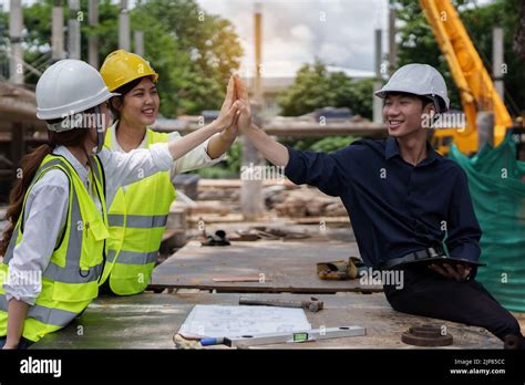 Structural Engineer And Architect Discussing And Working With Blueprints At The Outdoors