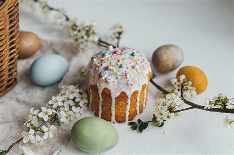 행복한 부활절 봄꽃과 고리버들 바구니가 있는 소박한 테이블에 세련된 부활절 빵과 천연 염색 계란 전통적인 부활절 바구니 음식 아이싱과 뿌려 부활절 케이크 계란 0명에 대한