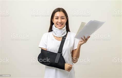 아시아 여자는 청구서 지불을 들고 팔과 다리가 부러졌다 여자는 지팡이 목발로 석고 캐스트 부목을 착용했습니다 목 칼라가 있는 슬링 지지 팔을 착용한 환자 생명 보험 및 사고