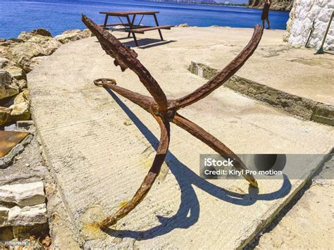 해안가에 오래된 녹슨 앵커 선박과 요트가있는 항구에는 앵커가 있습니다 관광객은 앵커에서 녹을 볼 수 있습니다 녹 물 녹에 해양