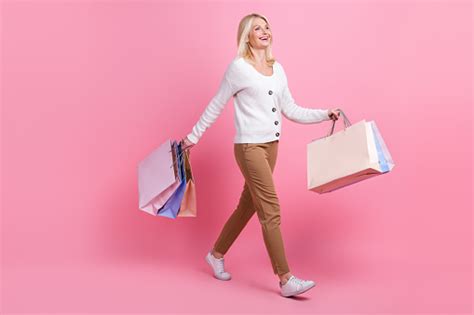 긍정적인 예쁜 아가씨의 전신 프로필 초상화는 분홍색 배경에 고립되어 걷고 있다 상점에 대한 스톡 사진 및 기타 이미지 상점