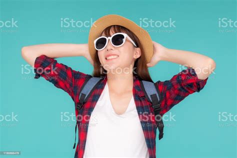 아름 다운 초상화 젊은 아시아 여자 선글라스와 모자를 착용 미소 흥분 하 고 자신감 여름 휴가 고립 된 파란색 배경 모델 소녀 패션 배낭 여행 개념을 즐길 수 있습니다