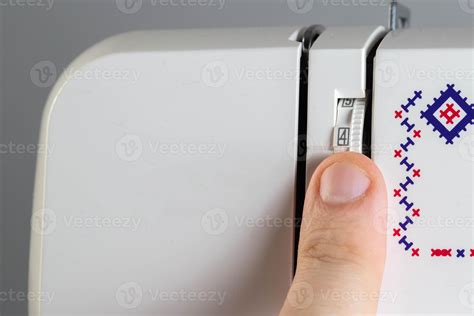 A Seamstress S Finger Adjusts The Stitch Length Dial Of A Sewing