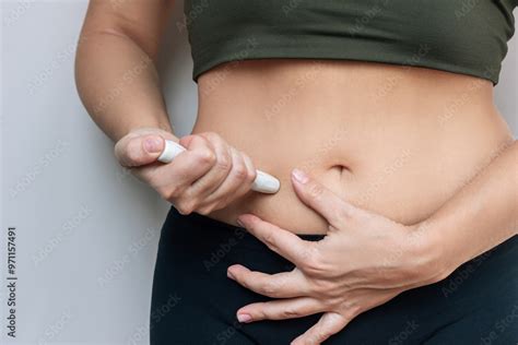 Ng Woman Putting A Hormonal Injection In Her Stomach With Pen Syringe
