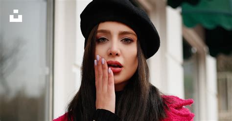 분홍색 코트와 모자를 쓰고 담배를 피우는 여자 사진 Unsplash의 무료 의류 이미지