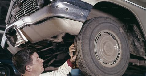 미국 1960년대경 주유소의 자동차 정비사 자동차가 주유소 리프트 랙에 있을 때 고무 타이어의 트레드 확인 사진 Unsplash의 자동차 이미지