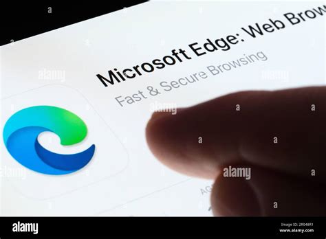 Microsoft Edge App Seen In App Store On The Screen Of Ipad And Blurred Finger Pointing At It