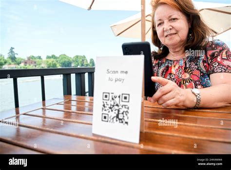 Femme Hispanique Mûre Scannant Un Code Qr Avec Son Smartphone Pour Payer Sa Facture De