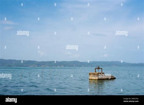 Lake Trasimeno Lake Landscape With Concrete Pier Seen From The Beach