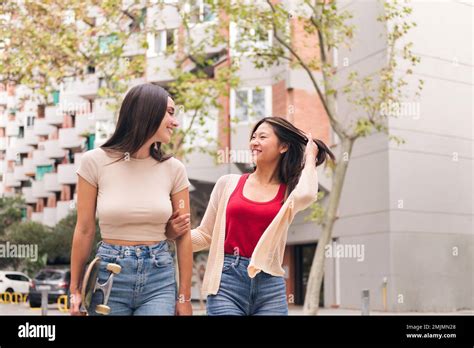 Women Strolling Happy Arm In Arm Through The City Stock Photo Alamy