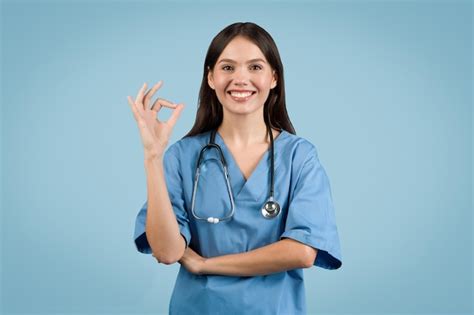 Premium Photo Confident Nurse In Blue Gives Ok Sign Signifying