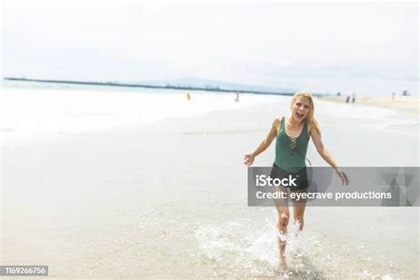 젊은 세대 Z 여자 와 긴 금발 머리 즐기는 물 해변 에 캘리포니아 재생 에 이 파도 와 물 20 29세에 대한 스톡 사진 및